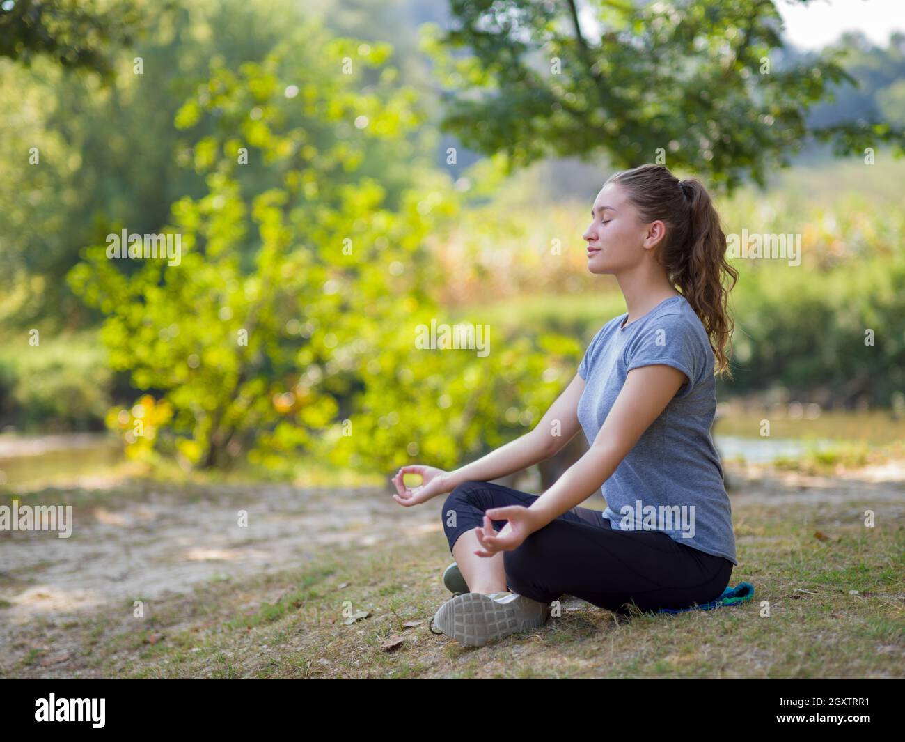 healthy woman relaxing while meditating and doing yoga exercise in the ...