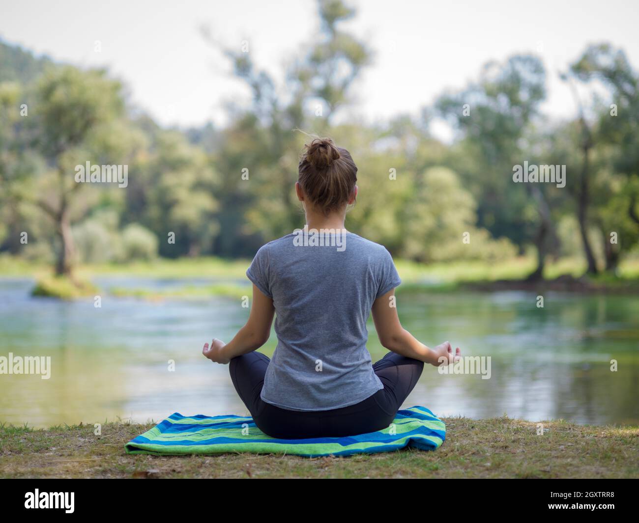 healthy woman relaxing while meditating and doing yoga exercise in the ...