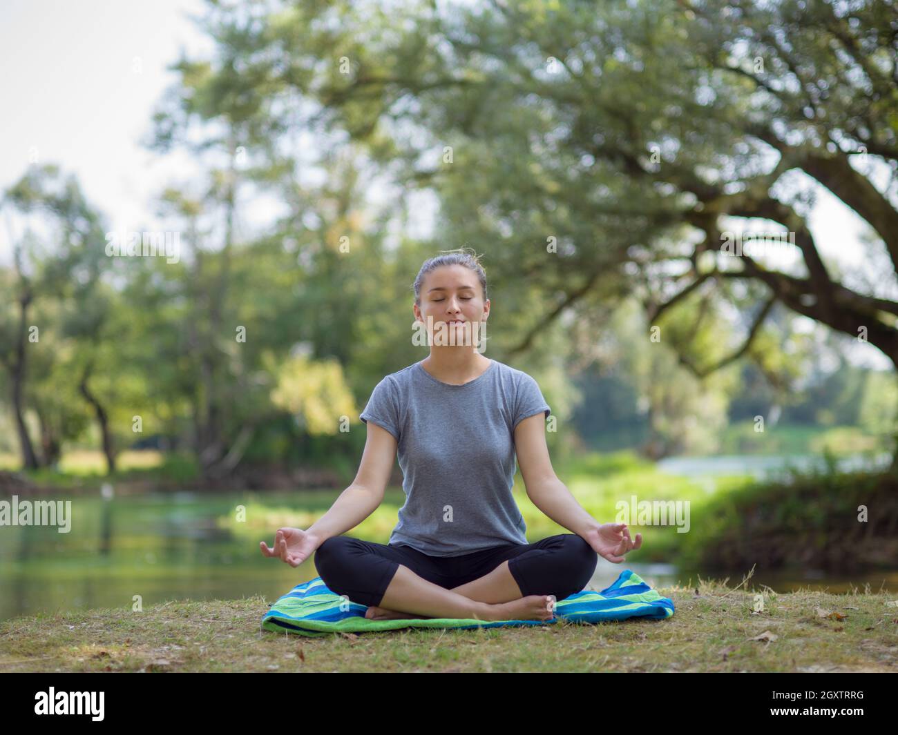 healthy woman relaxing while meditating and doing yoga exercise in the ...