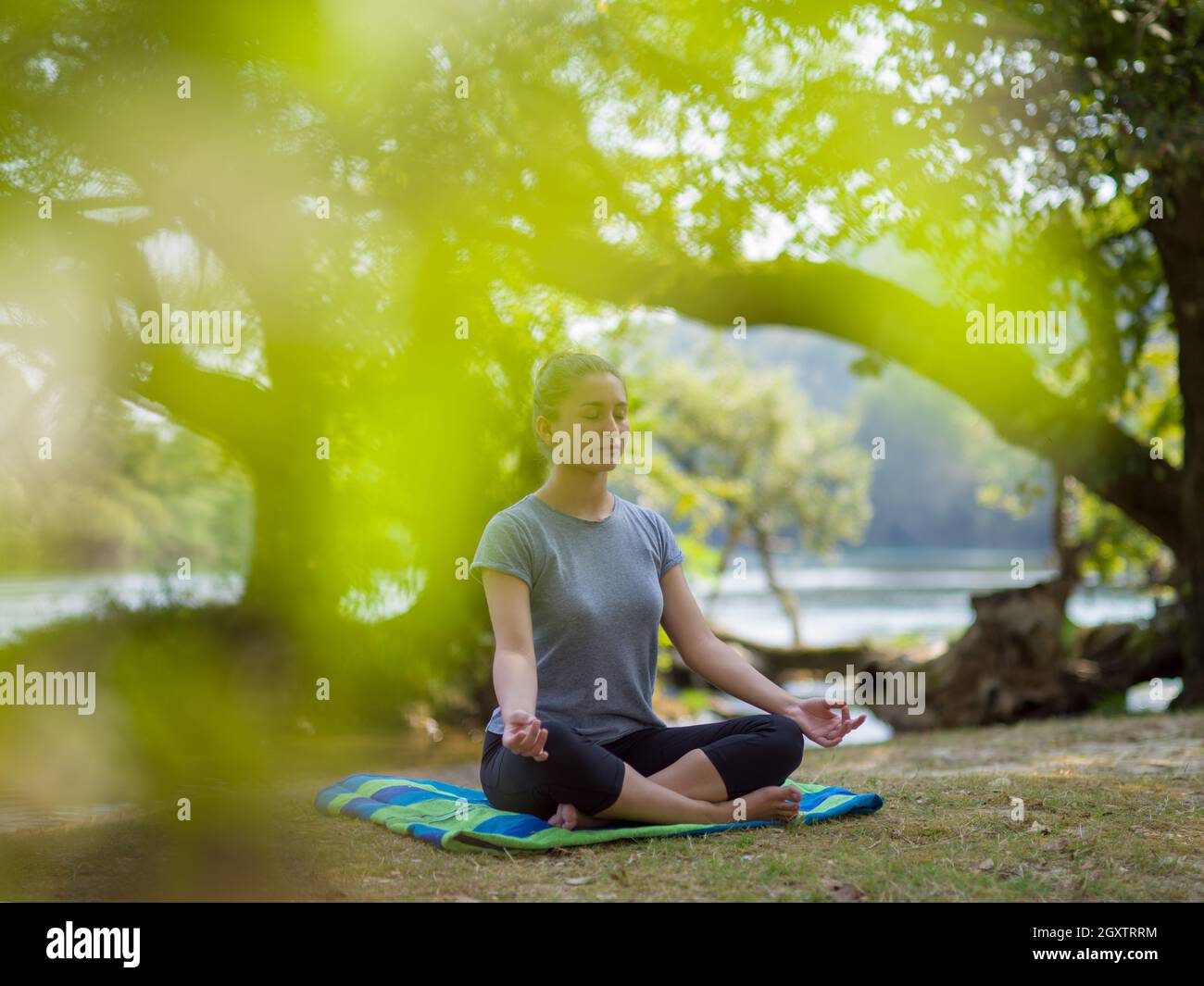 healthy woman relaxing while meditating and doing yoga exercise in the ...