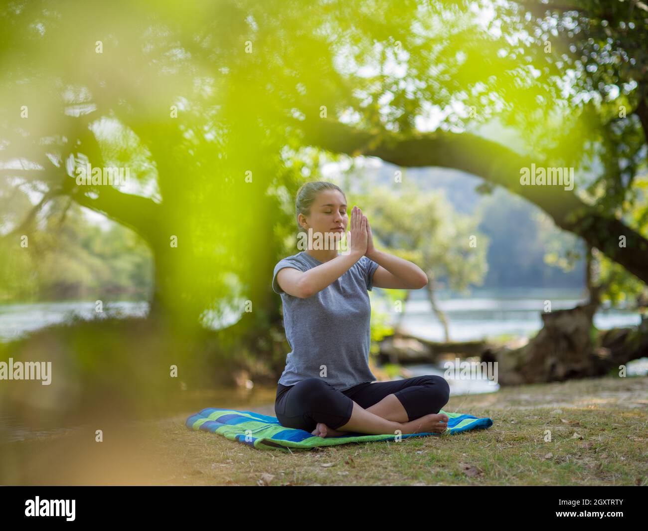 healthy woman relaxing while meditating and doing yoga exercise in the ...