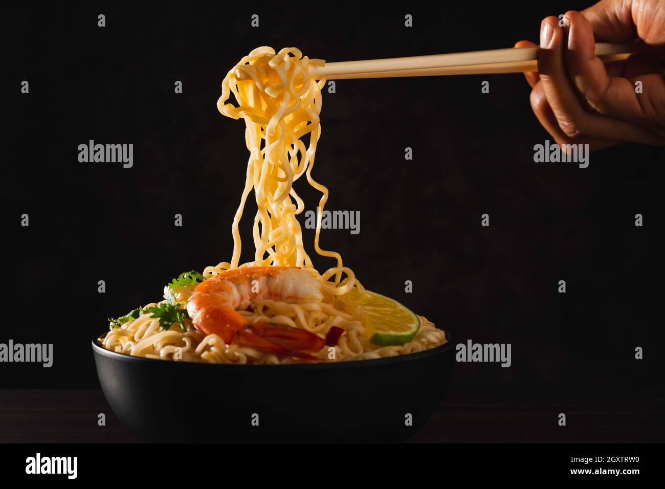 Hand using chopsticks pickup instant noodles with smokes isolated on ...