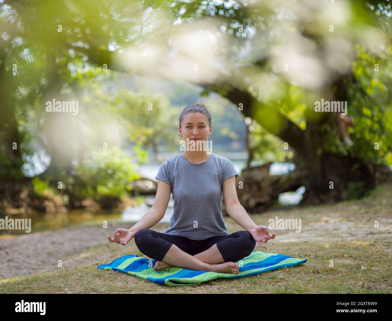healthy woman relaxing while meditating and doing yoga exercise in the ...