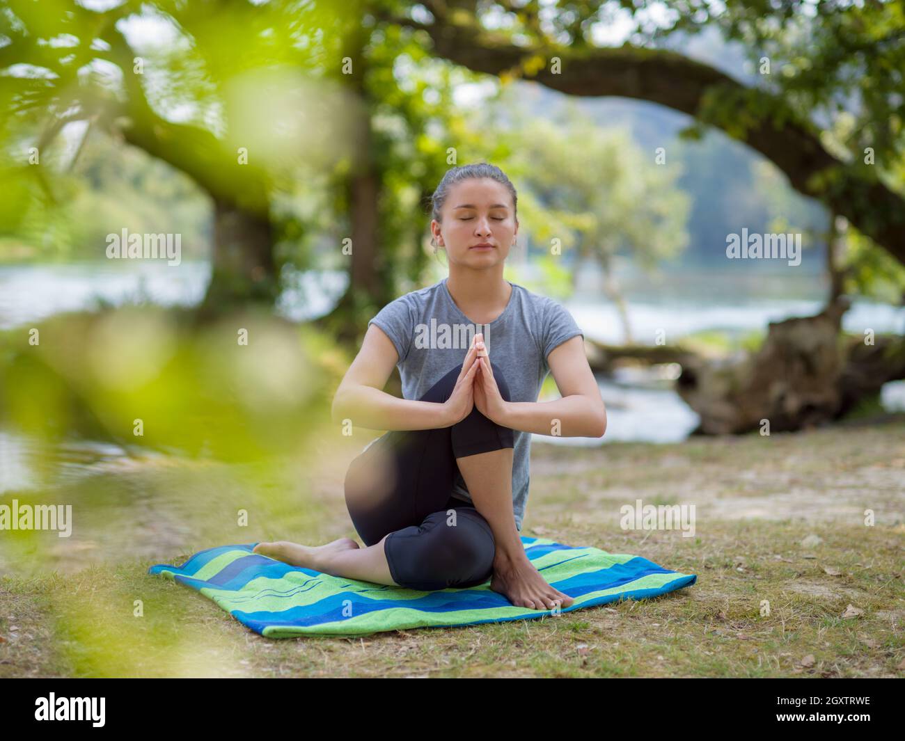 healthy woman relaxing while meditating and doing yoga exercise in the ...