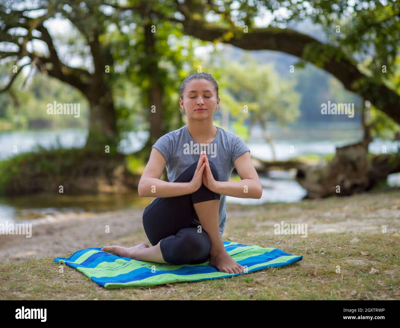 healthy woman relaxing while meditating and doing yoga exercise in the ...