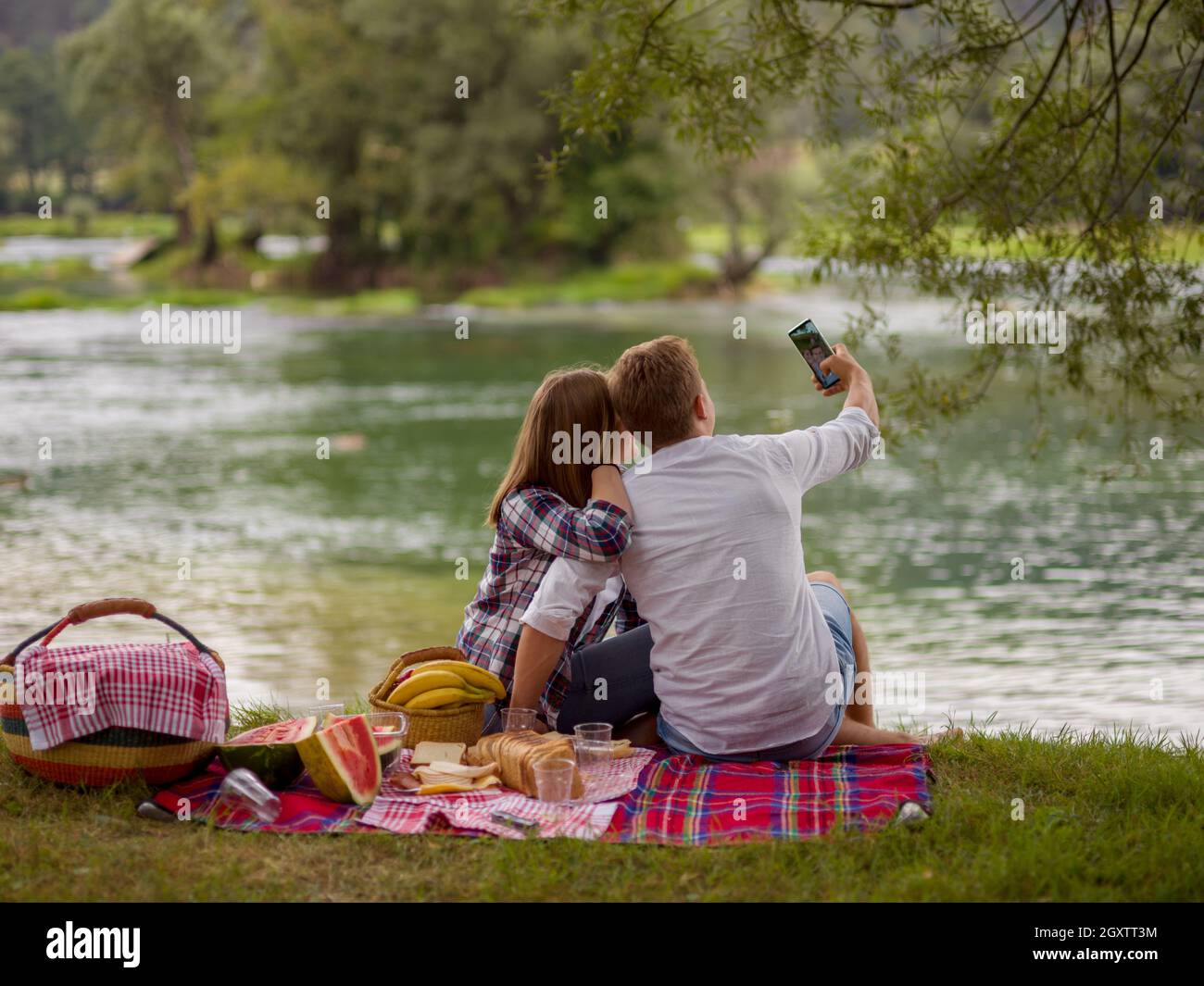 Couple in love taking a selfie by mobile phone while enjoying picnic ...