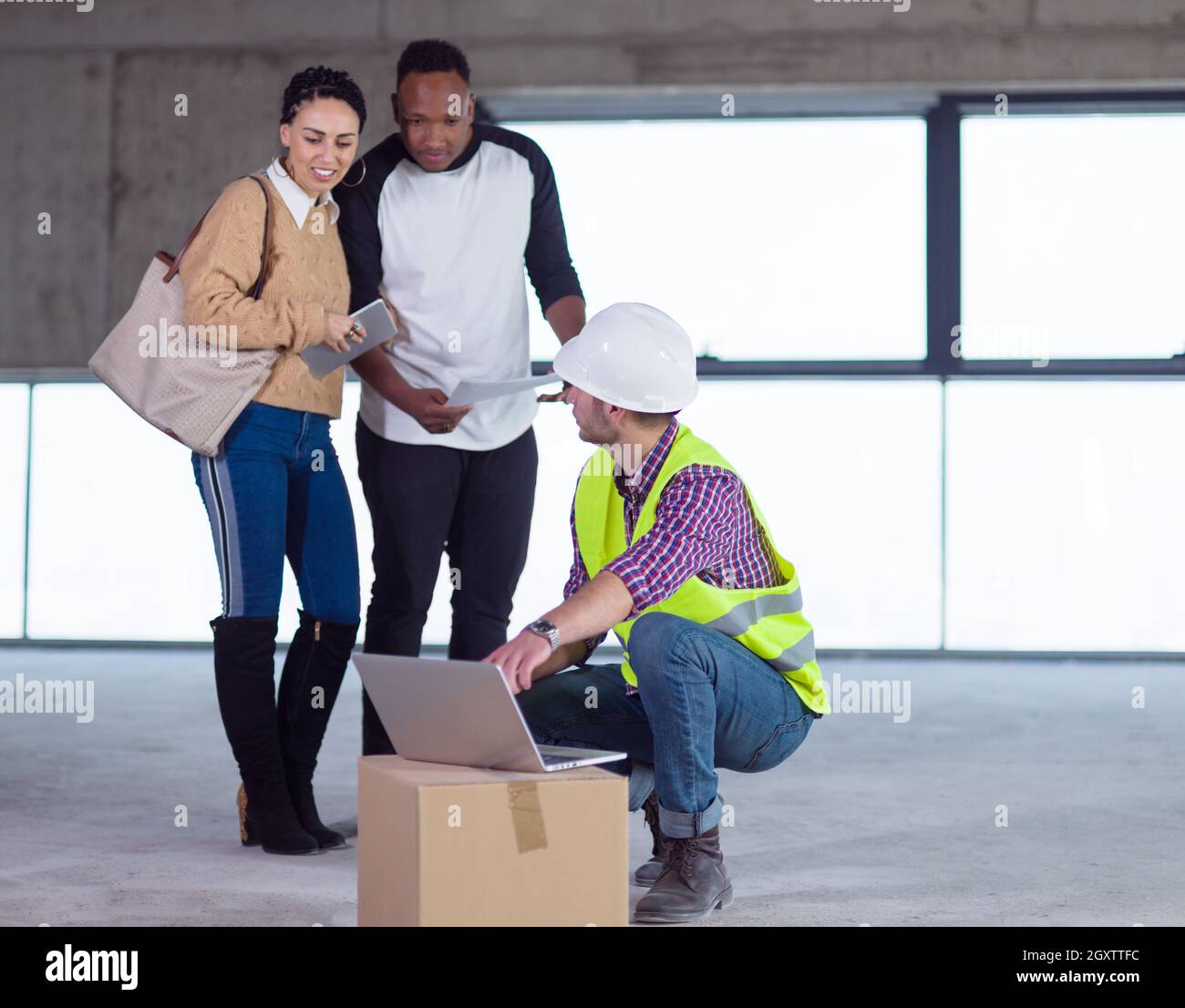 construction worker using laptop computer while showing house design ...