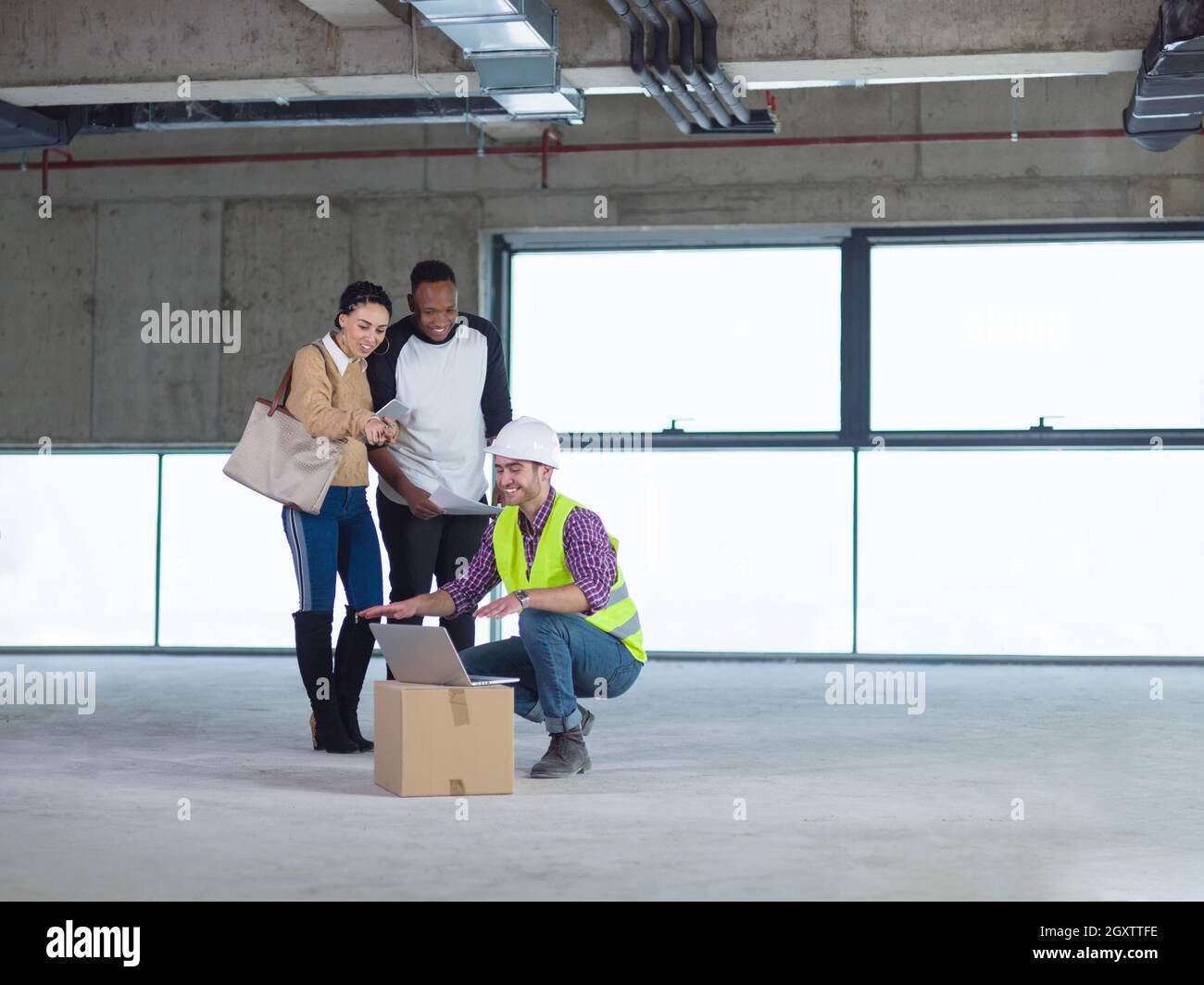 construction worker using laptop computer while showing house design ...