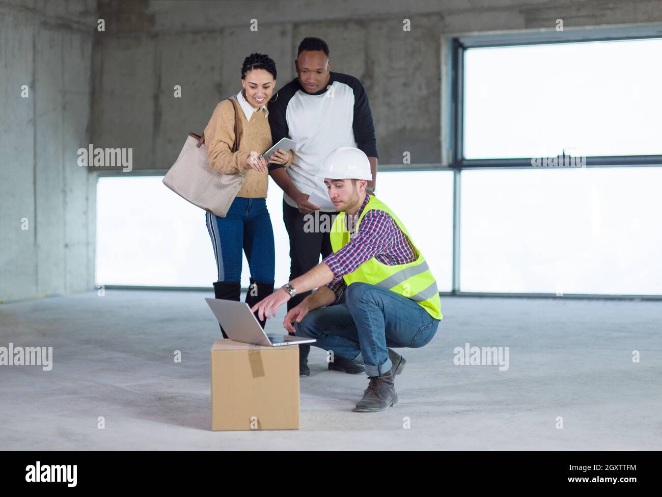 construction worker using laptop computer while showing house design ...