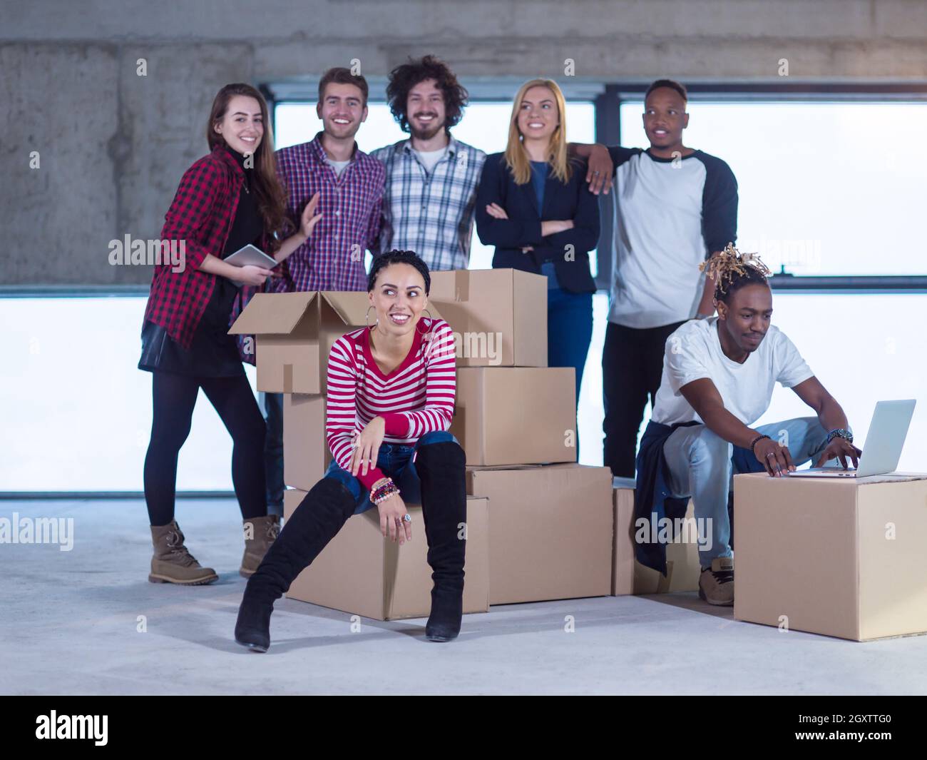 portrait of happy multiethnic business team with cardboard boxes around ...
