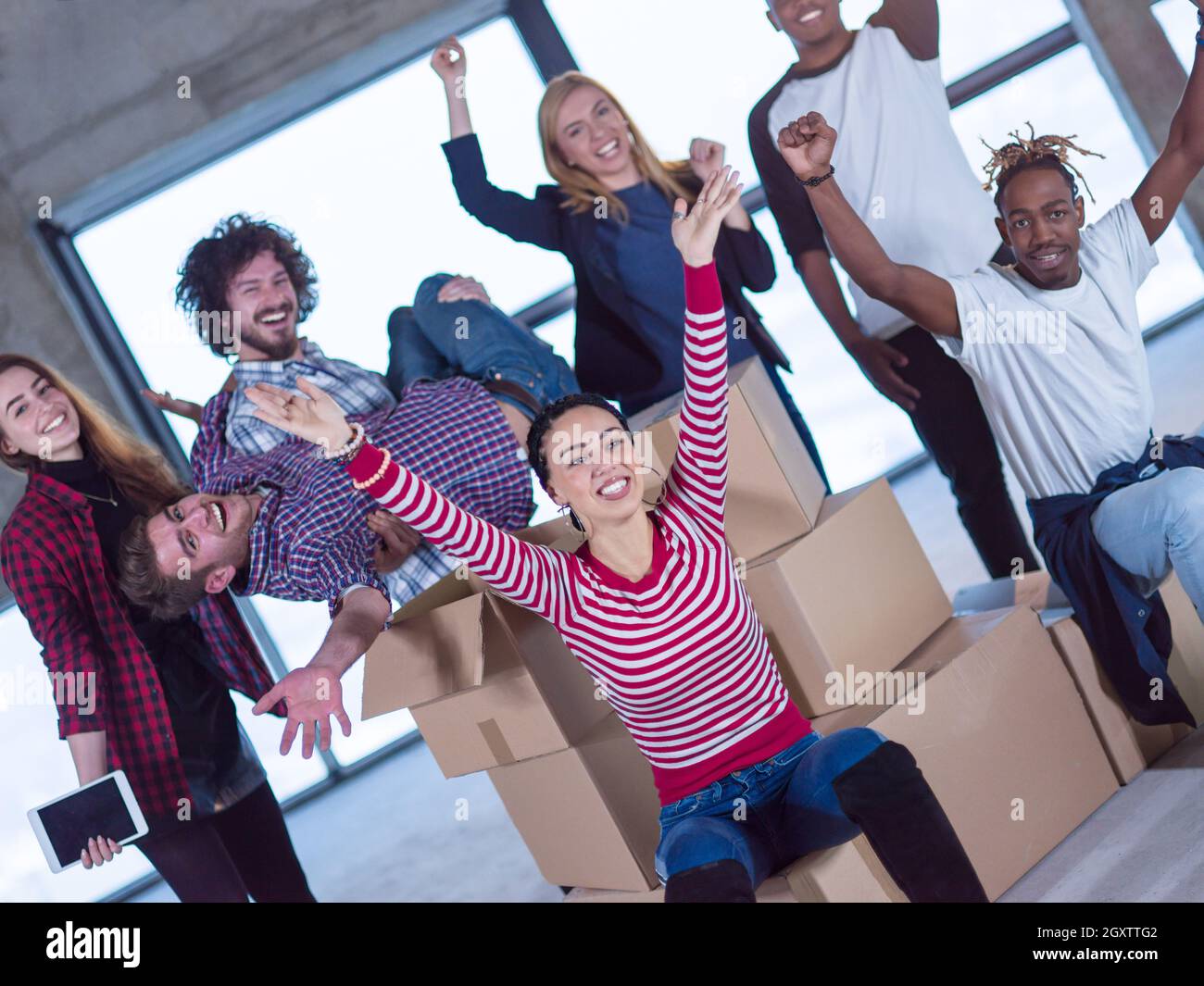 portrait of happy multiethnic business team with cardboard boxes around ...