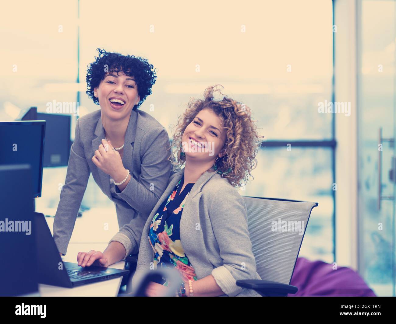 group of young female software developers using laptop and desktop ...