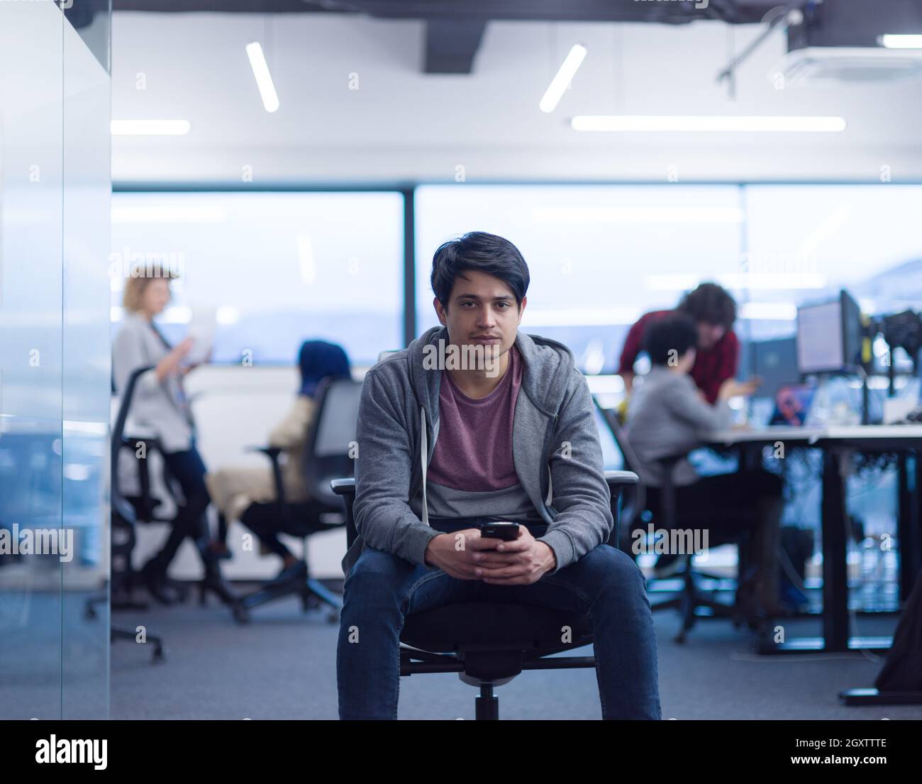 young indian male software developer using mobile phone writing ...