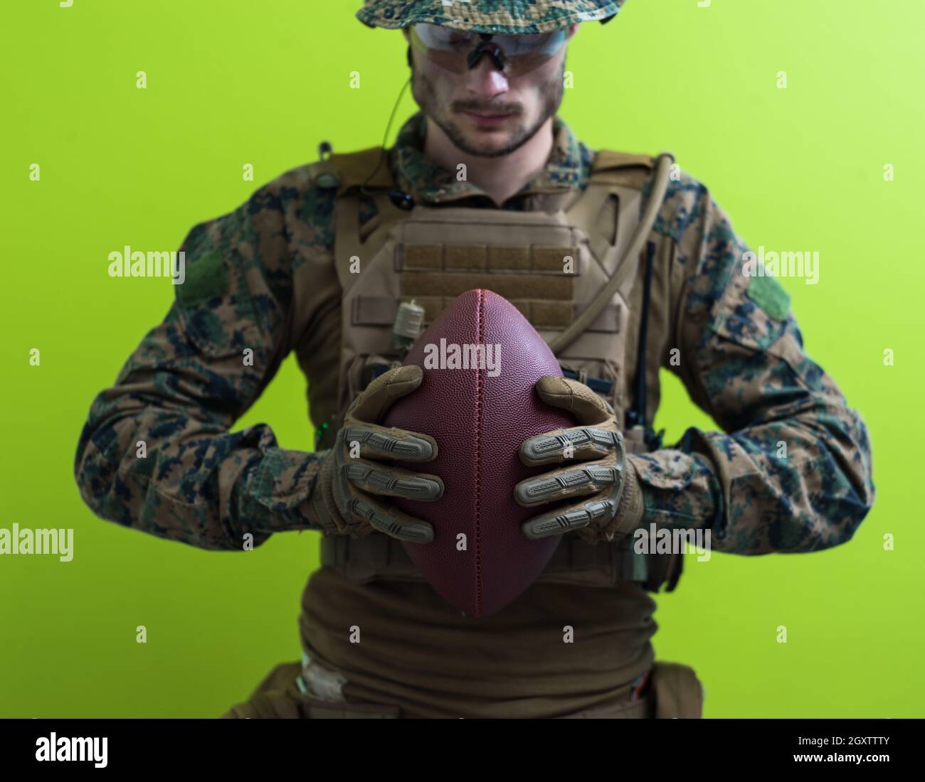 solder holding american football ball ready for game concept of peace ...