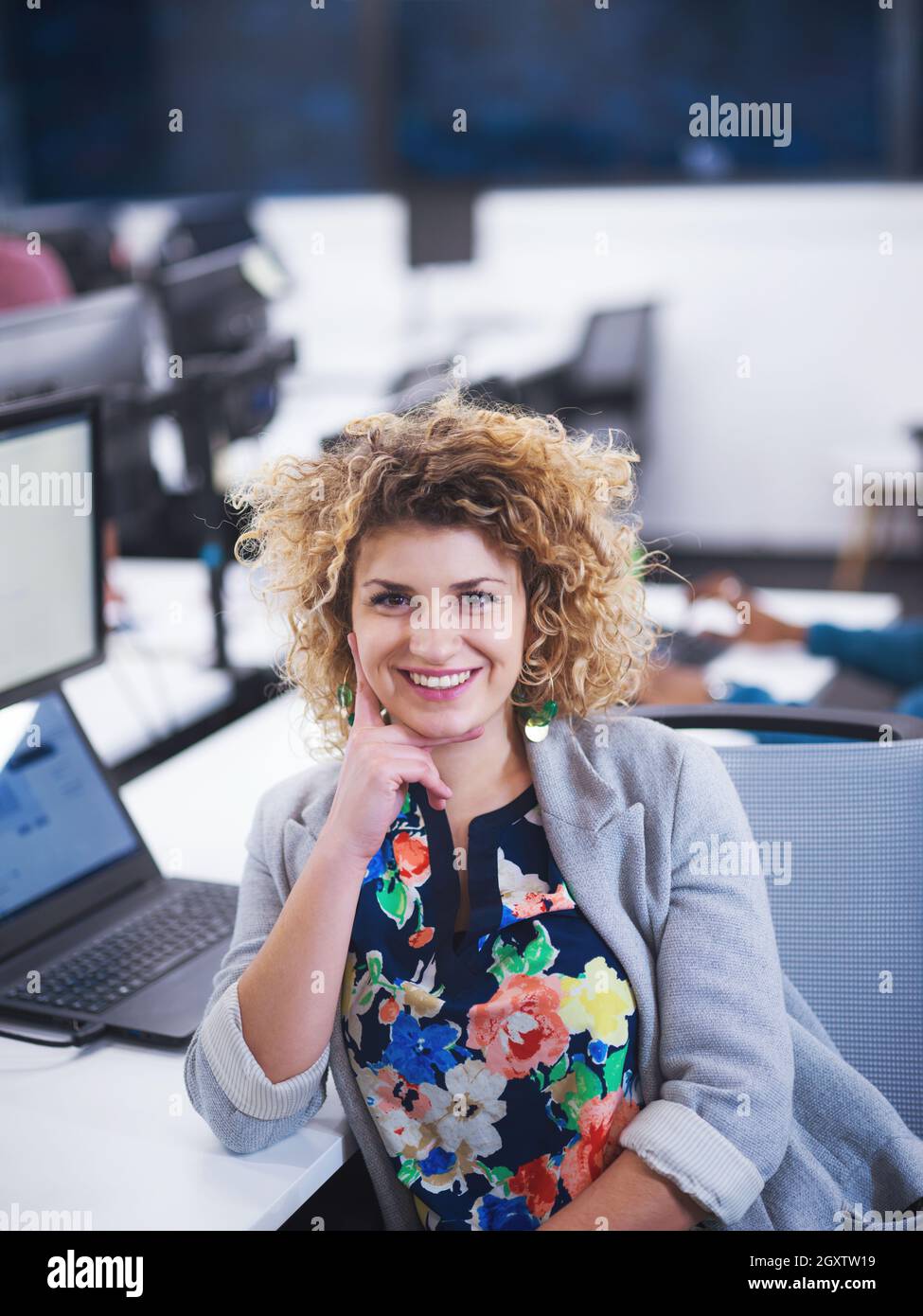 portrait of young female software developer at busy startup office with ...