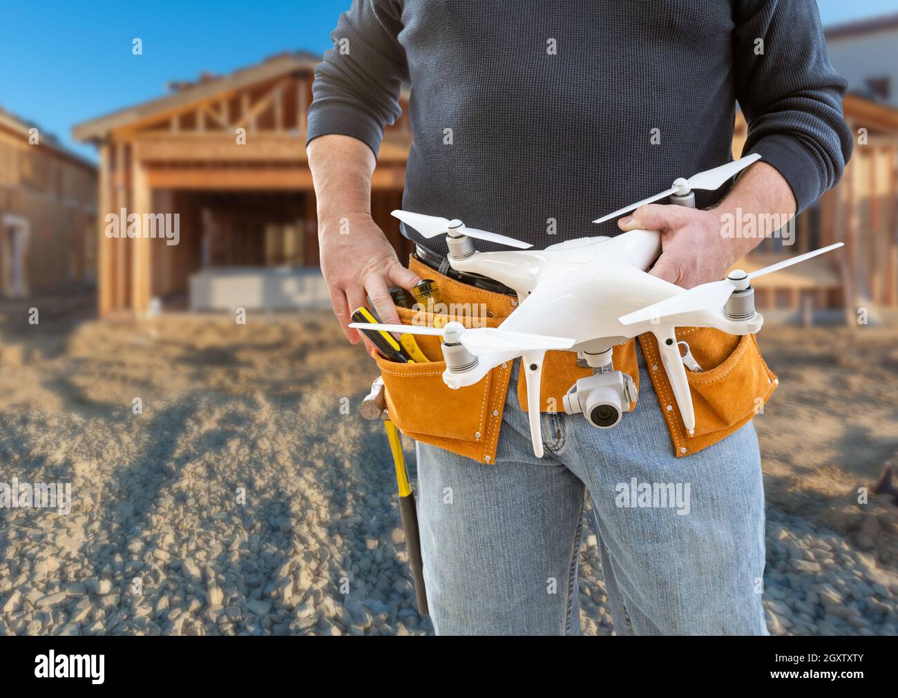 Construction Worker and Drone Pilot With Toolbelt Holding Drone At ...