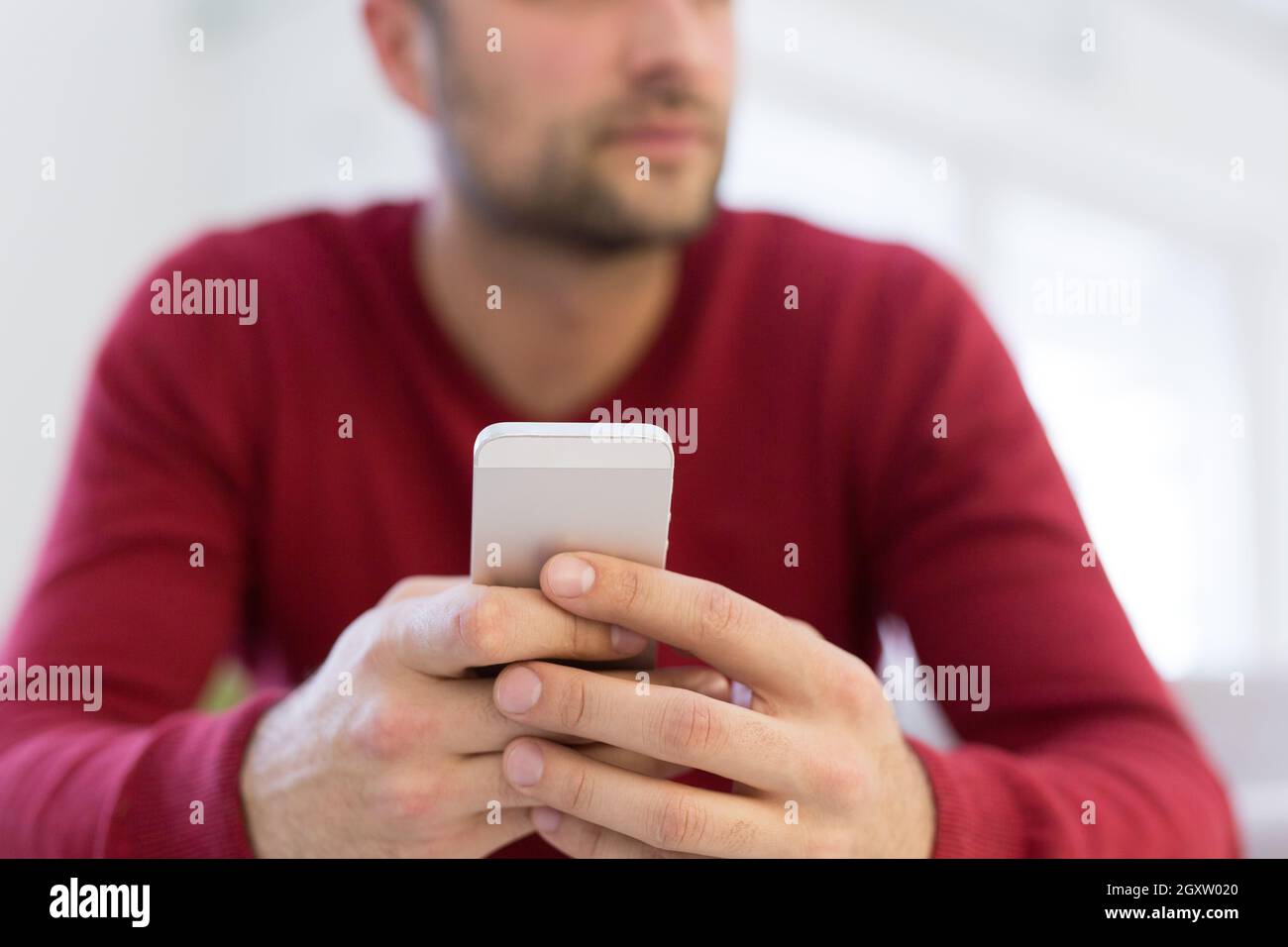 Handsome casual young man using a mobile phone at home Stock Photo - Alamy