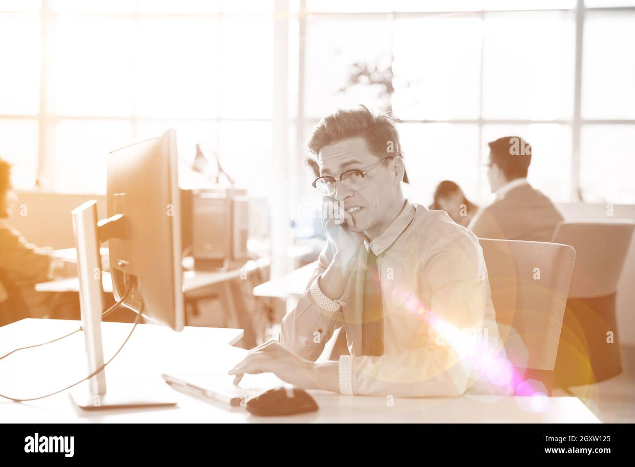 Young businessman programer in big bright office at work using computer ...