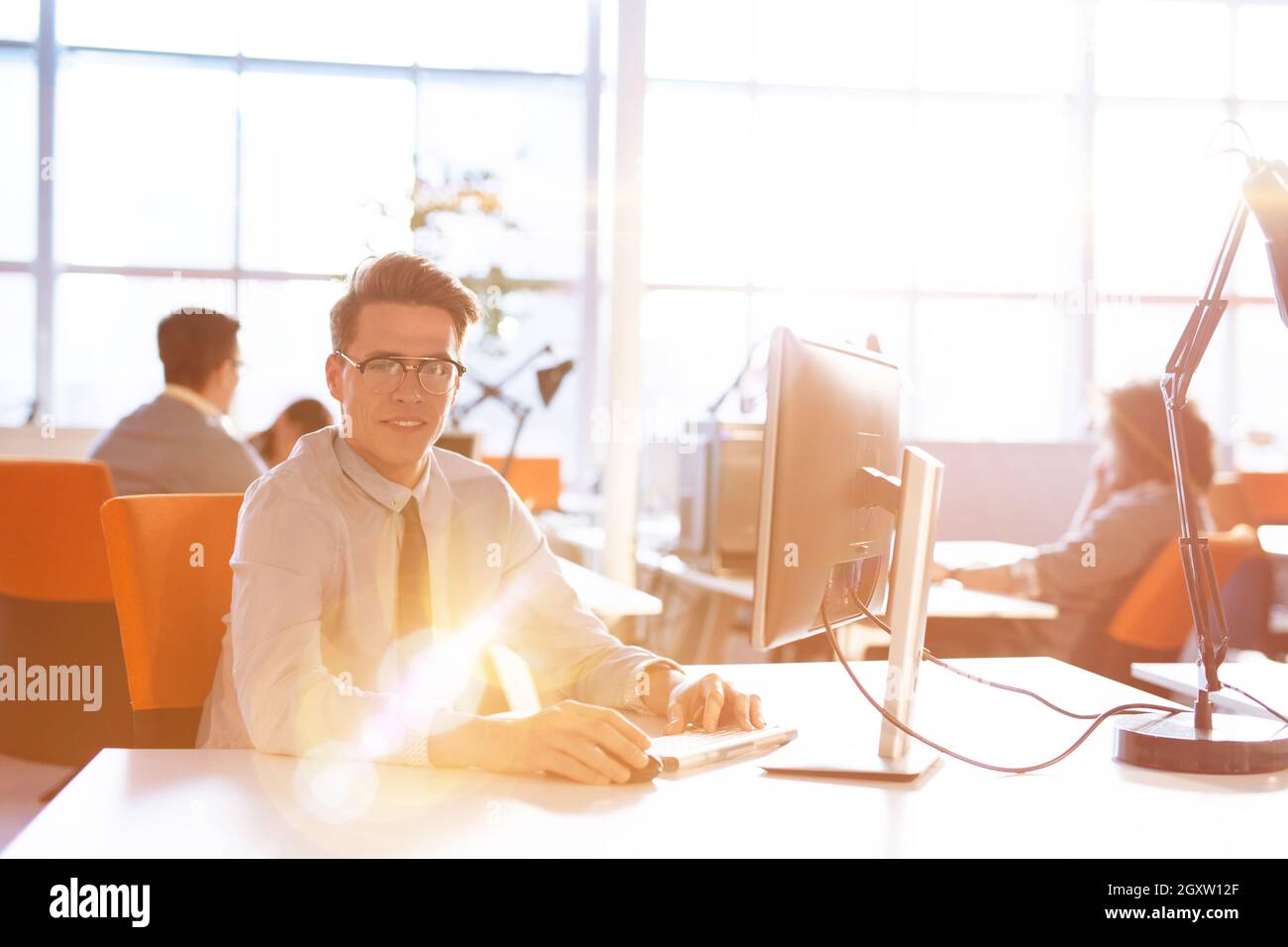 Young businessman programer in big bright office at work using computer ...