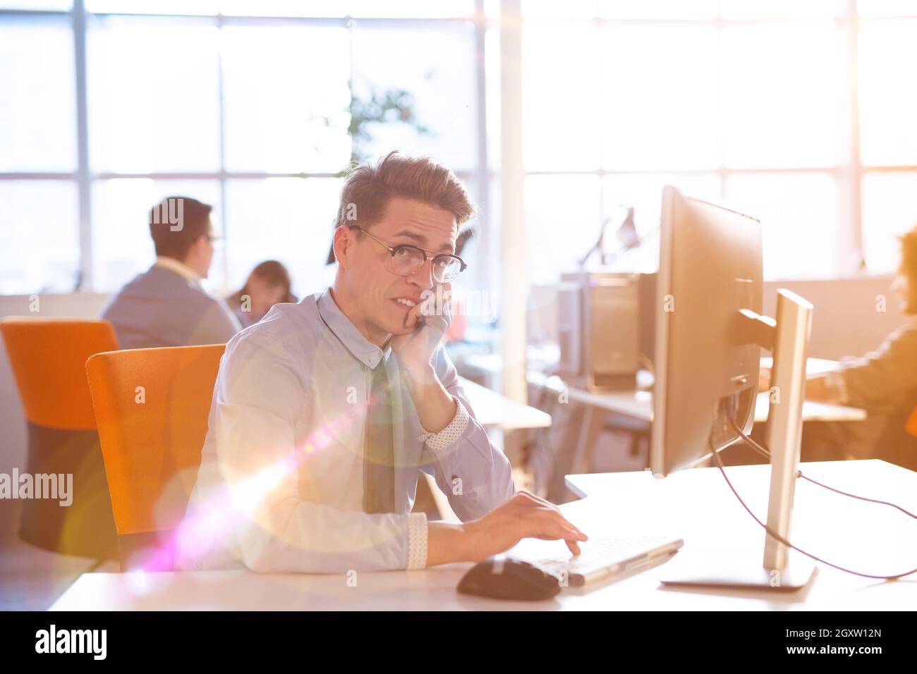 Young businessman programer in big bright office at work using computer ...