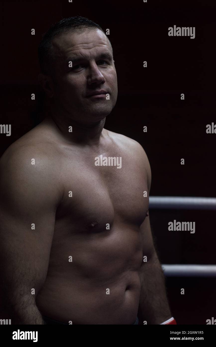 portrait of muscular professional kickboxer who standing in the ring ...
