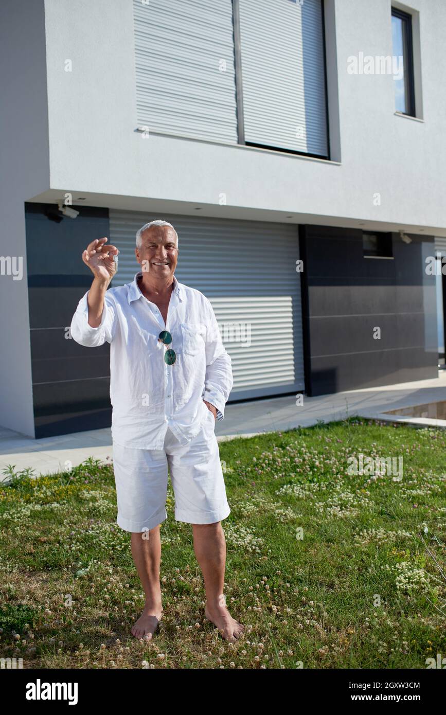 senior man in front of luxury modern home villa Stock Photo - Alamy