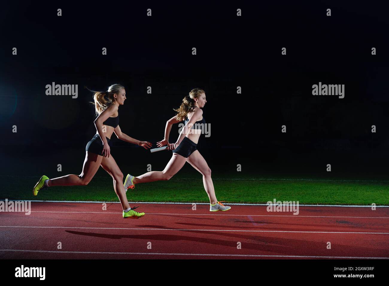 Athletics runners passing baton in hi-res stock photography and images ...