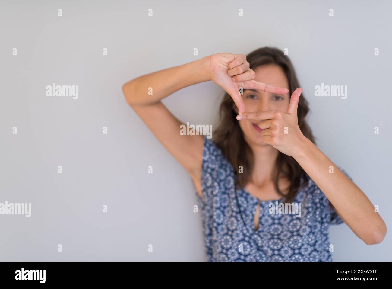 young happy woman showing framing hand gesture isolated on a white ...