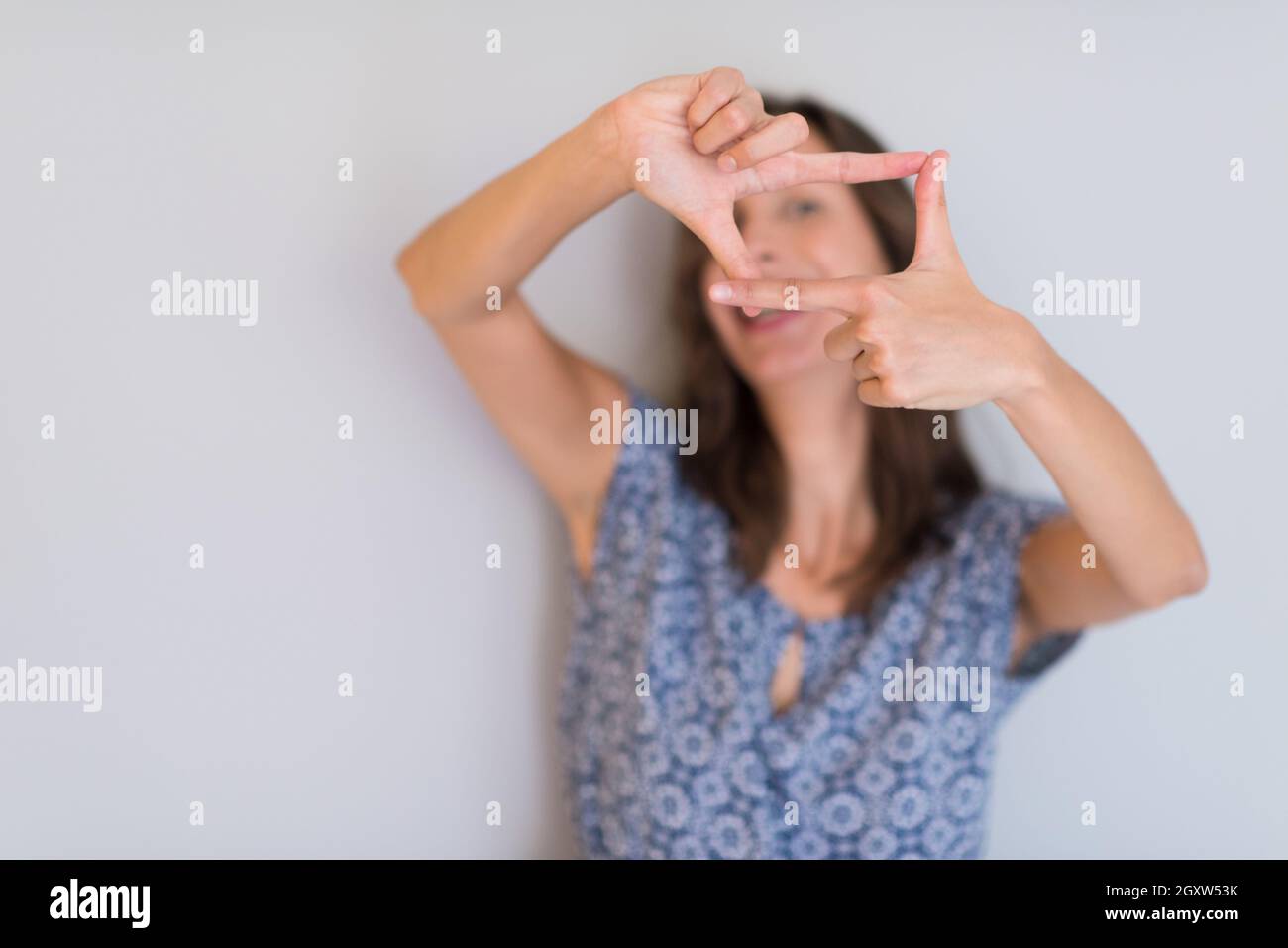 young happy woman showing framing hand gesture isolated on a white ...