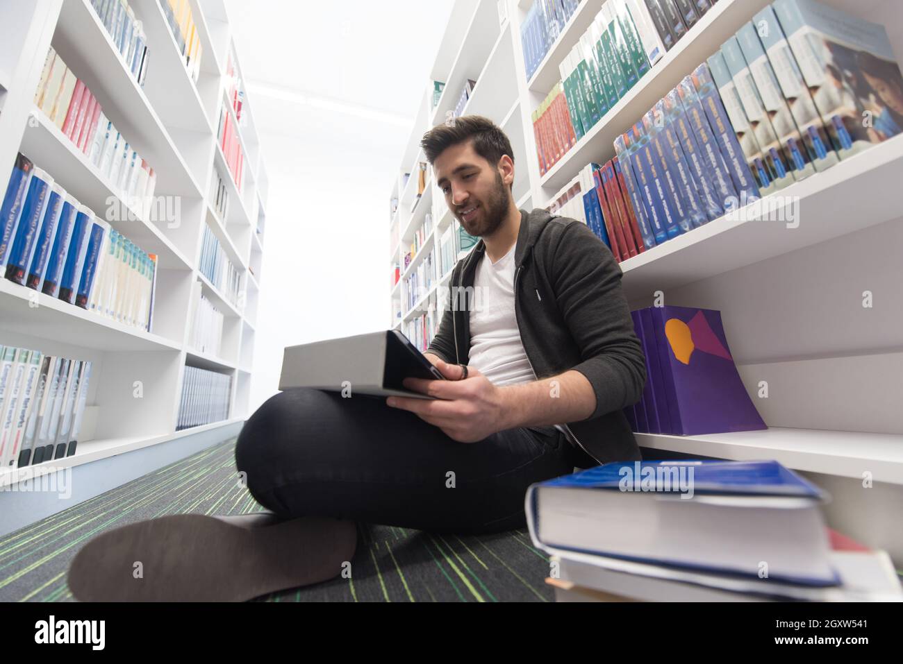 Student reading book in school library. Study lessons for exam. Hard ...