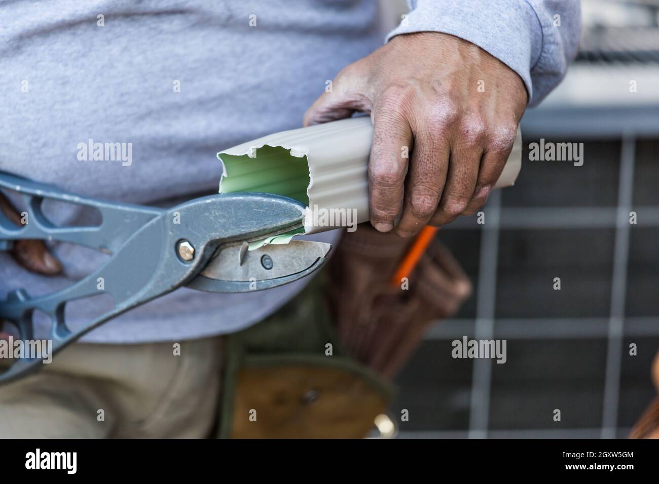 Worker Cutting Aluminum Rain Gutter With Heavy Shears Stock Photo - Alamy