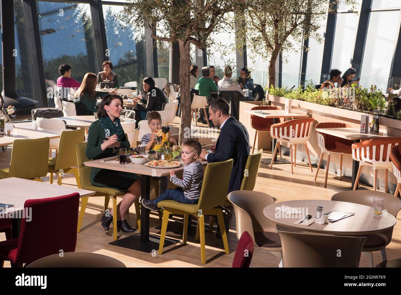 Young parents enjoying lunch time with their children at a luxury ...