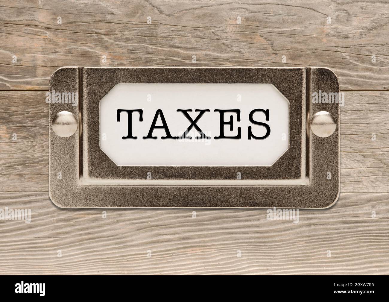 Taxes Metal File Label Frame on Wood Background Stock Photo - Alamy
