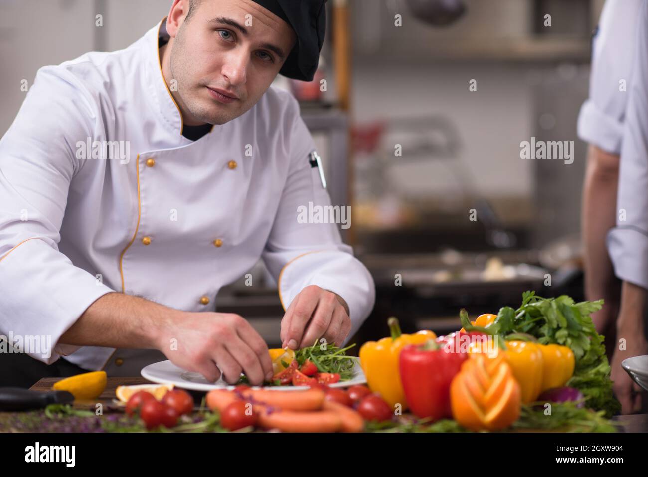 chef serving vegetable salad on plate in restaurant kitchen Stock Photo ...