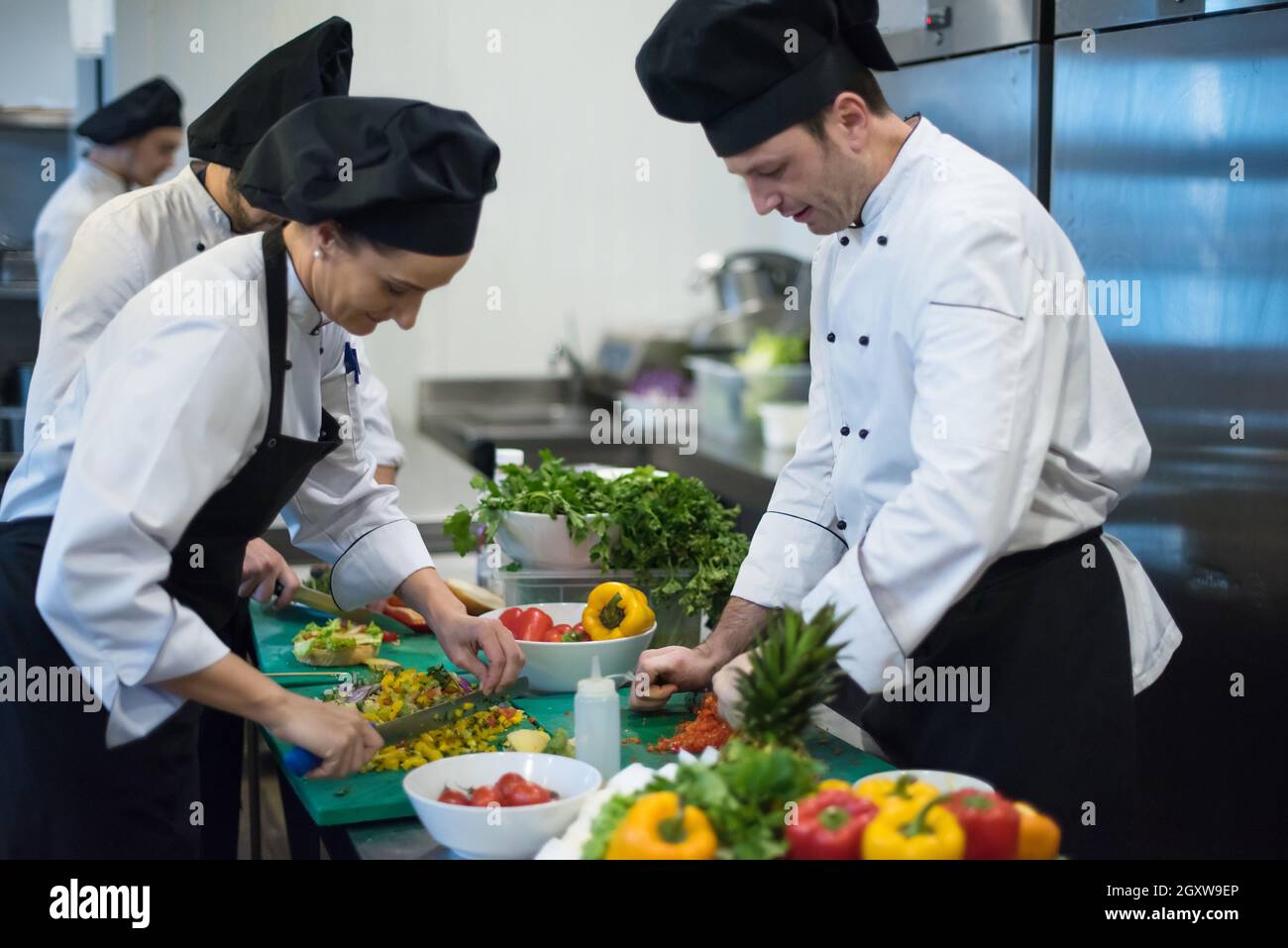 Professional team cooks and chefs preparing meals at busy hotel or ...