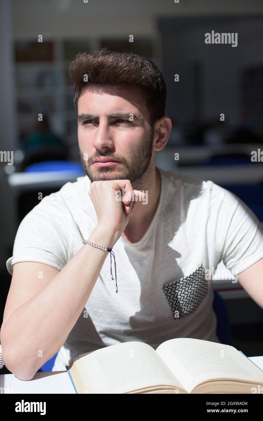 Student reading book in school library. Study lessons for exam. Hard ...