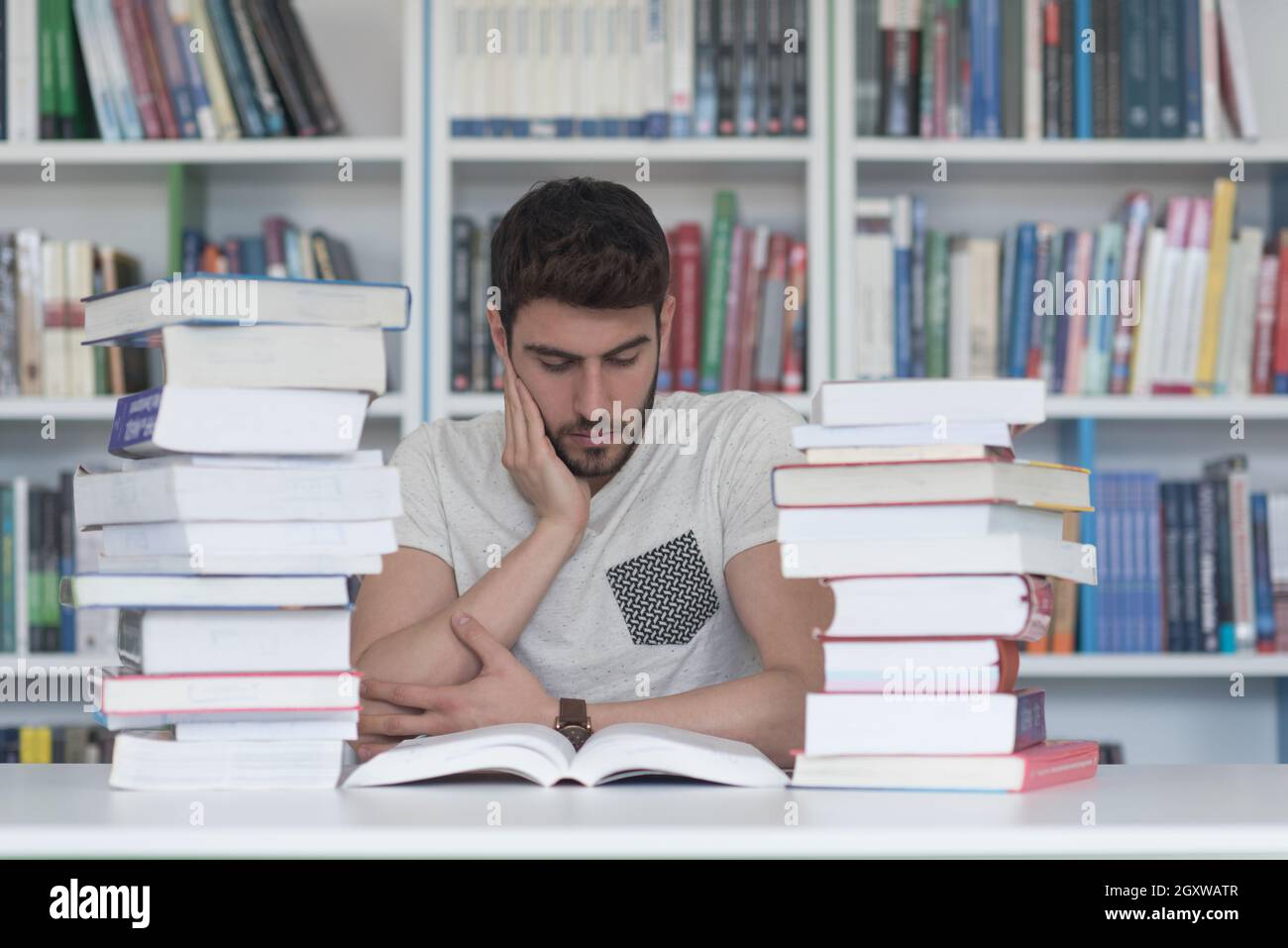 Student reading book in school library. Study lessons for exam. Hard ...
