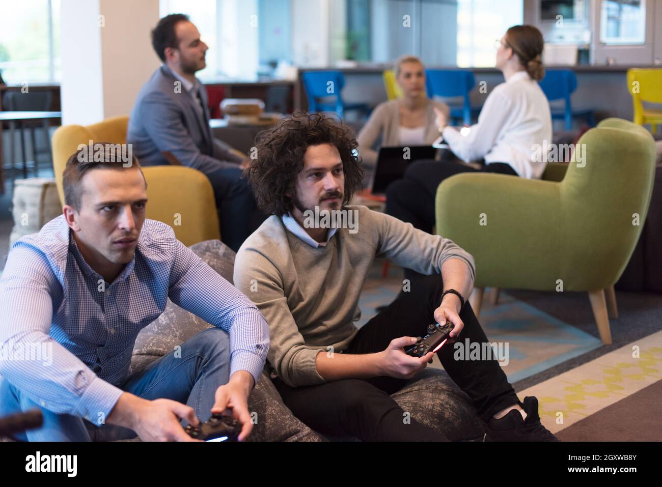 Work hard play hard. Workers Playing computer games in creative startup ...