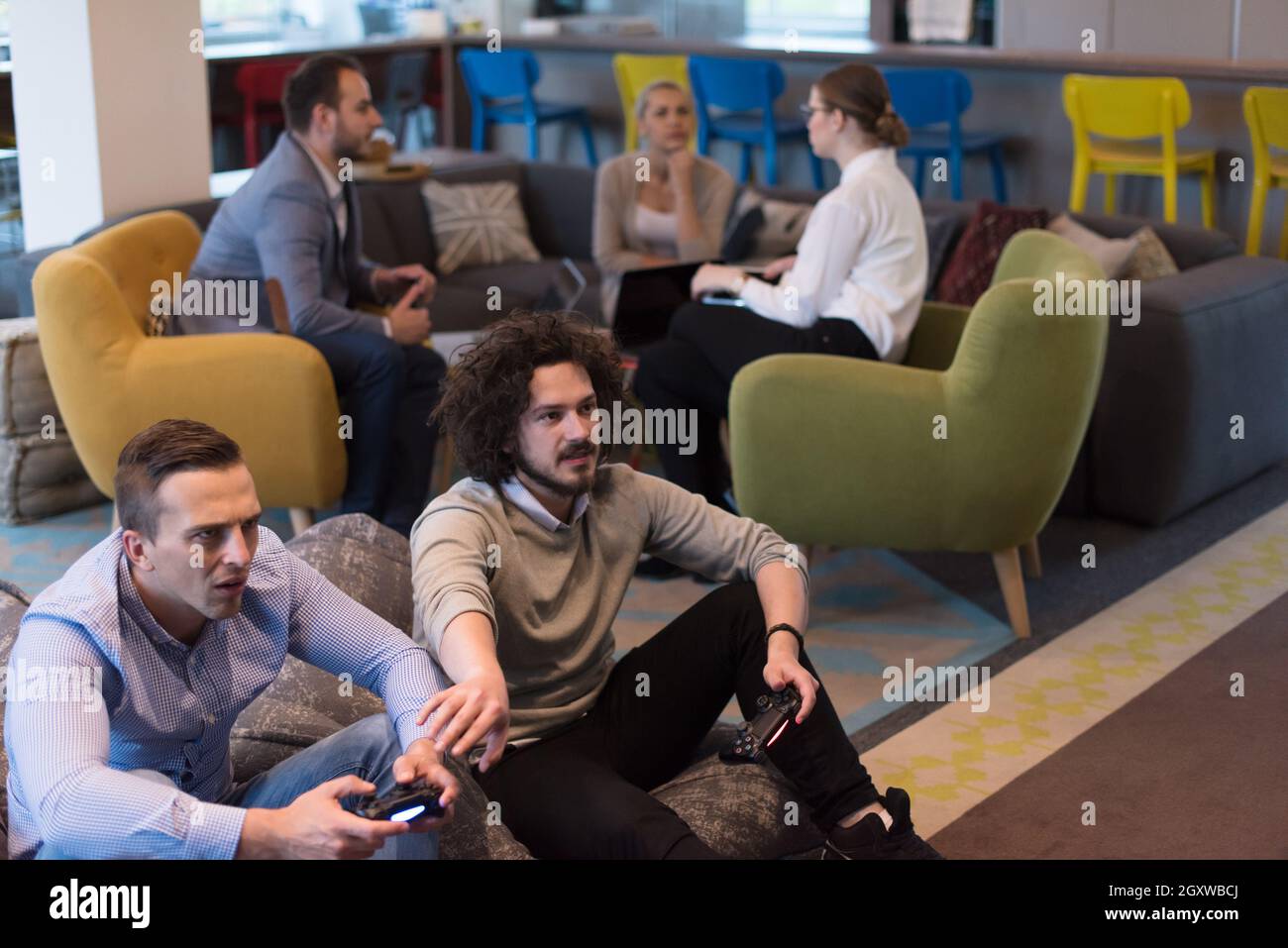 Work hard play hard. Workers Playing computer games in creative startup ...