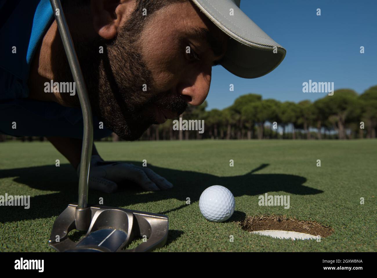 golf player blowing ball in hole. concept of cheating and success Stock ...