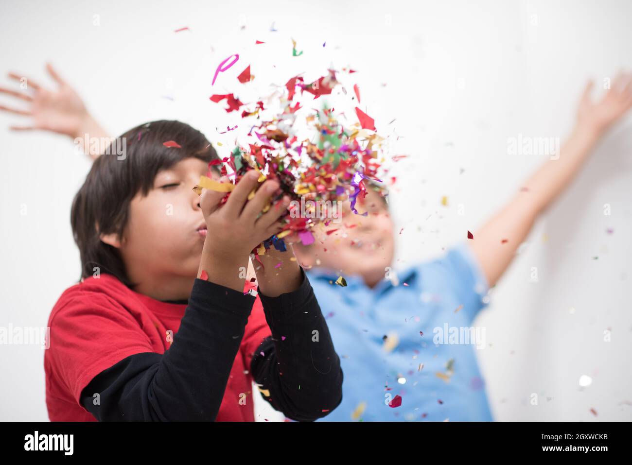 Happy kids celebrating party with blowing confetti Stock Photo - Alamy