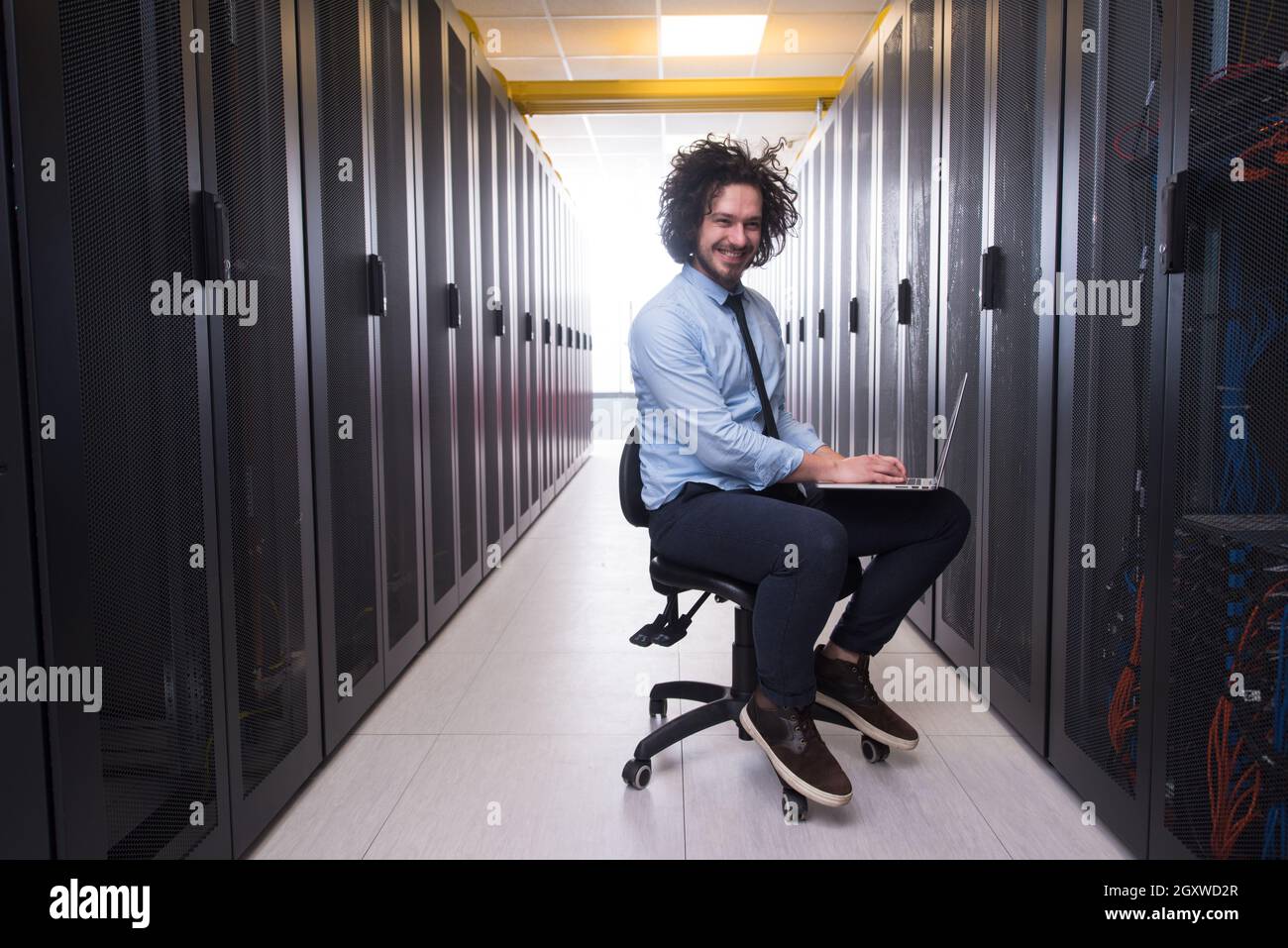 Male IT engineer working on a laptop in server room at modern data ...