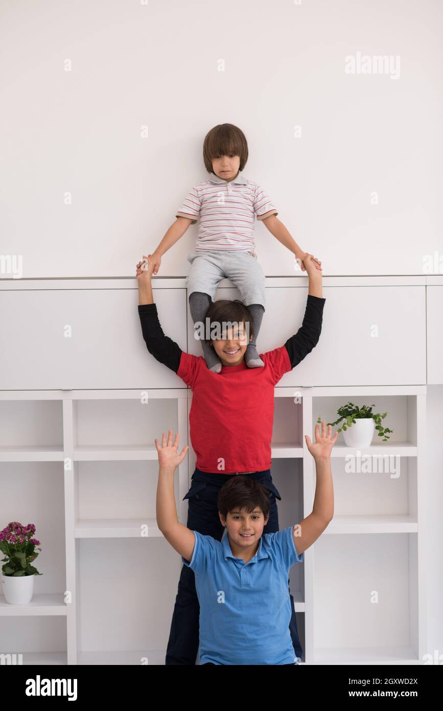 happy young boys having fun and posing line up piggyback in new modern ...