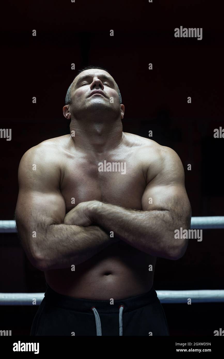 portrait of muscular professional kickboxer with arms crossed in the ...