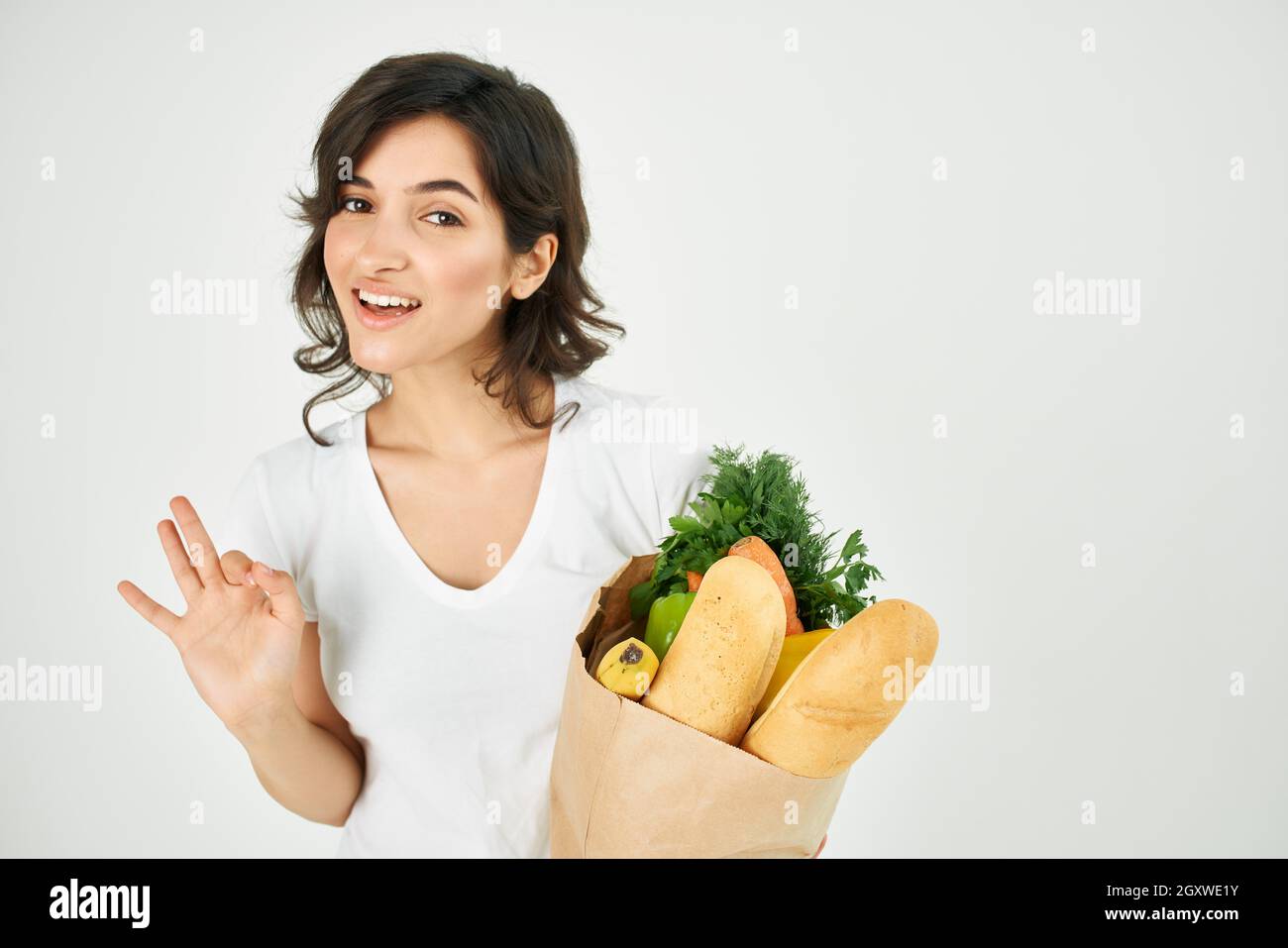 woman with a package of groceries vegetables healthy eating positive ...