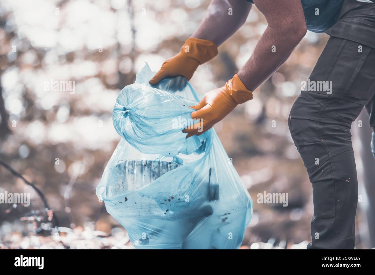 Hand picking up garbage plastic for cleaning the woods or parks ...