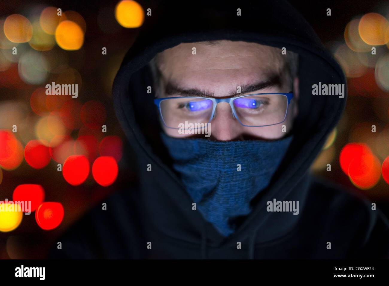 Young talented hacker using laptop computer while working in dark ...