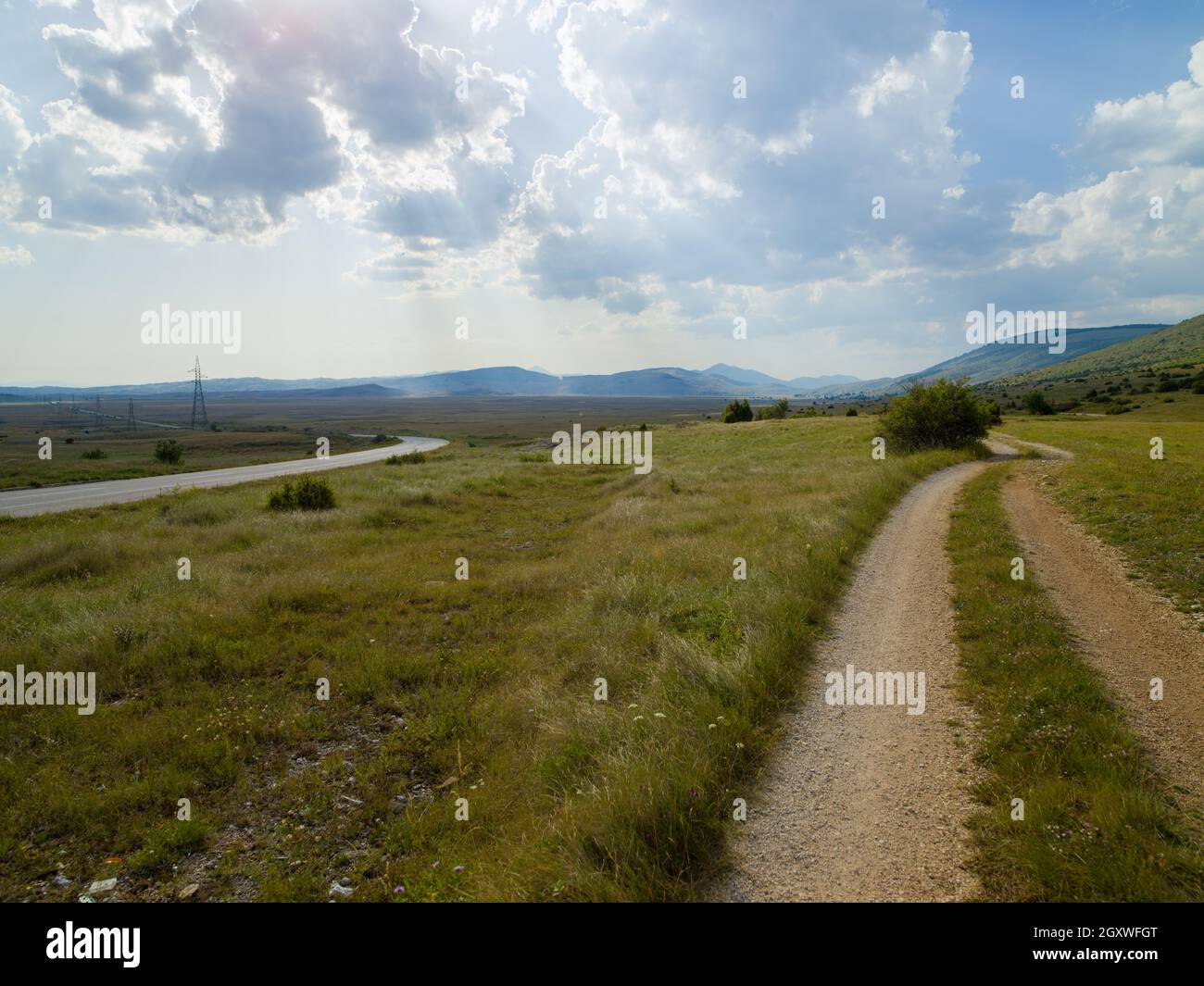 Evening summer landscape with green grass, road and clouds Stock Photo ...