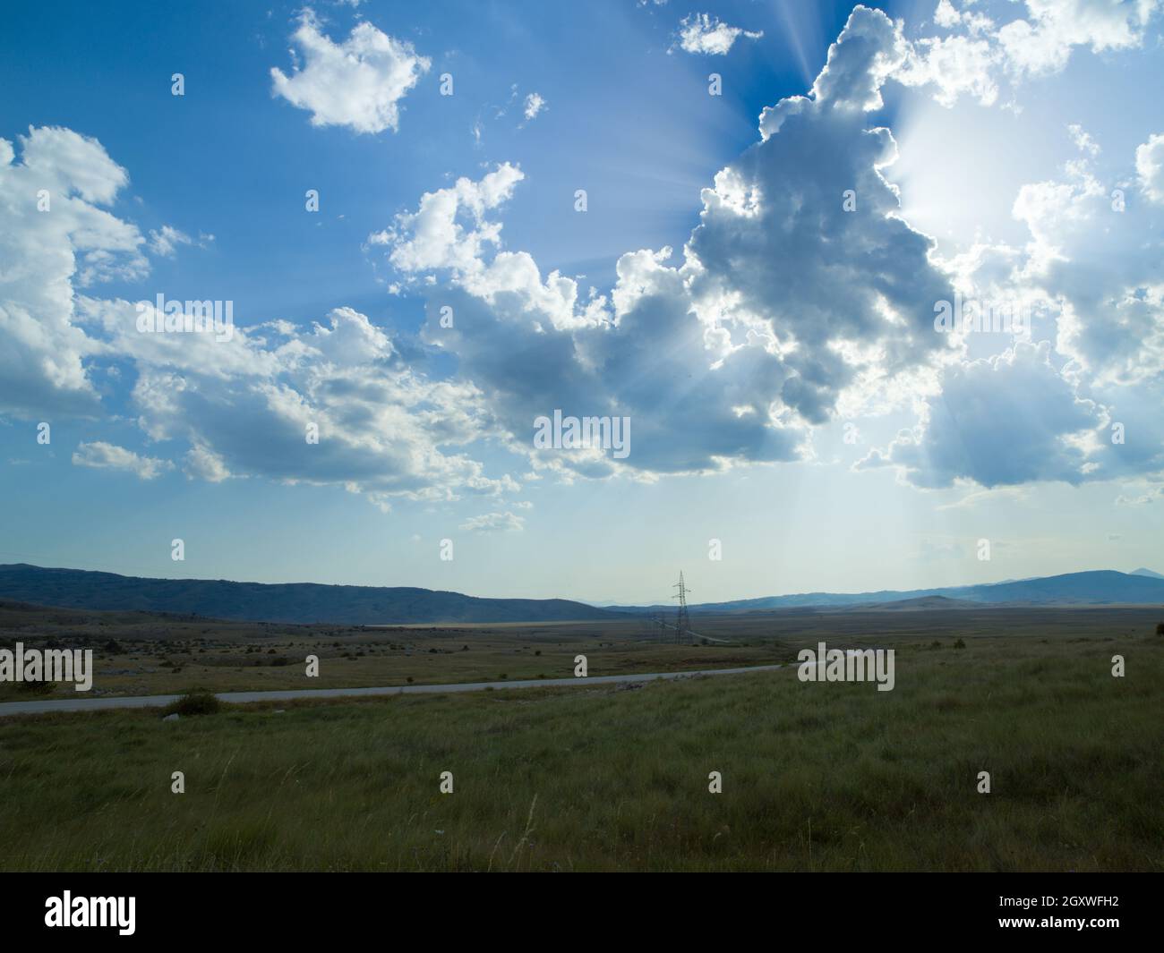 Evening summer landscape with green grass, road and clouds Stock Photo ...