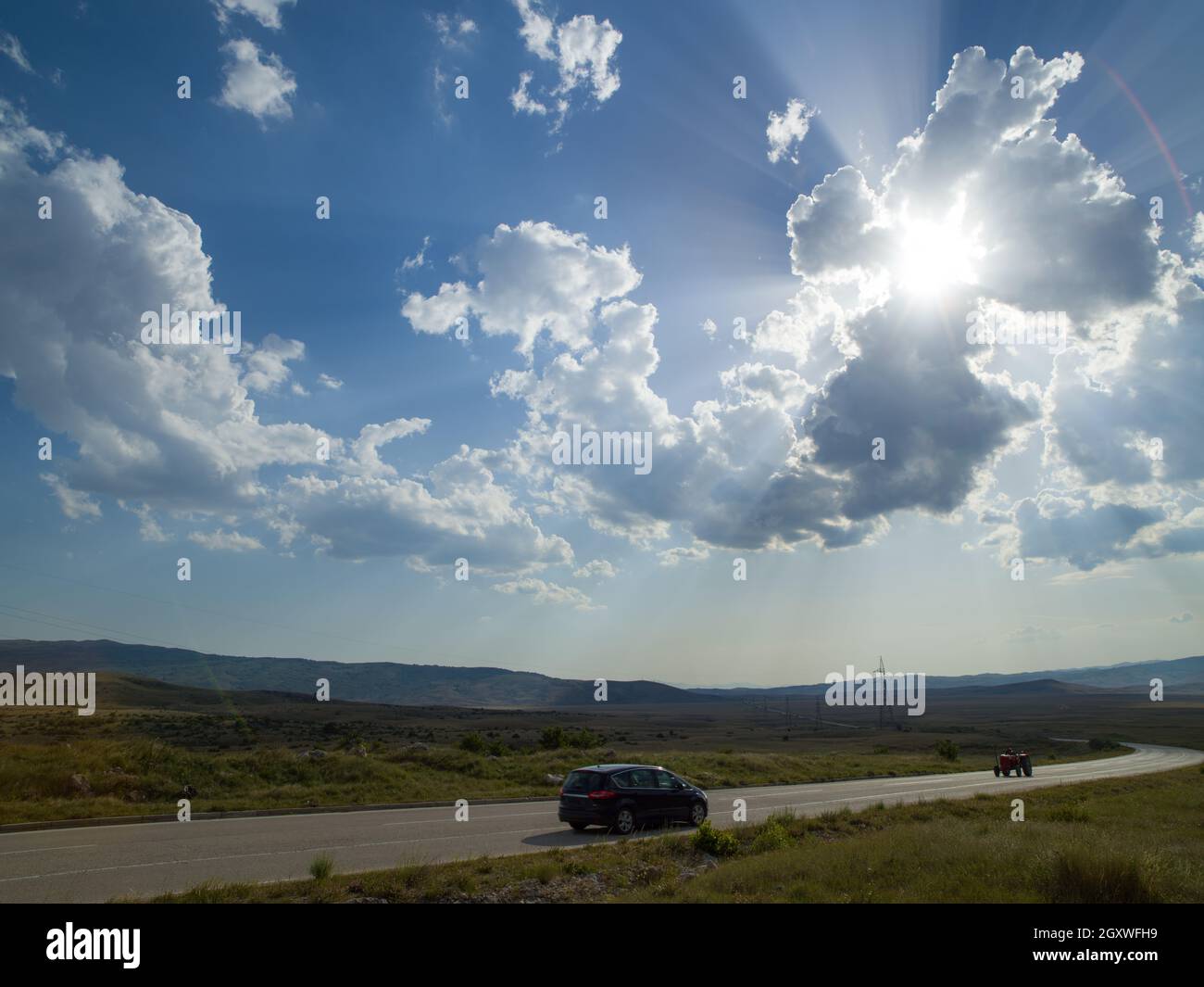 Evening summer landscape with green grass, road and clouds Stock Photo ...